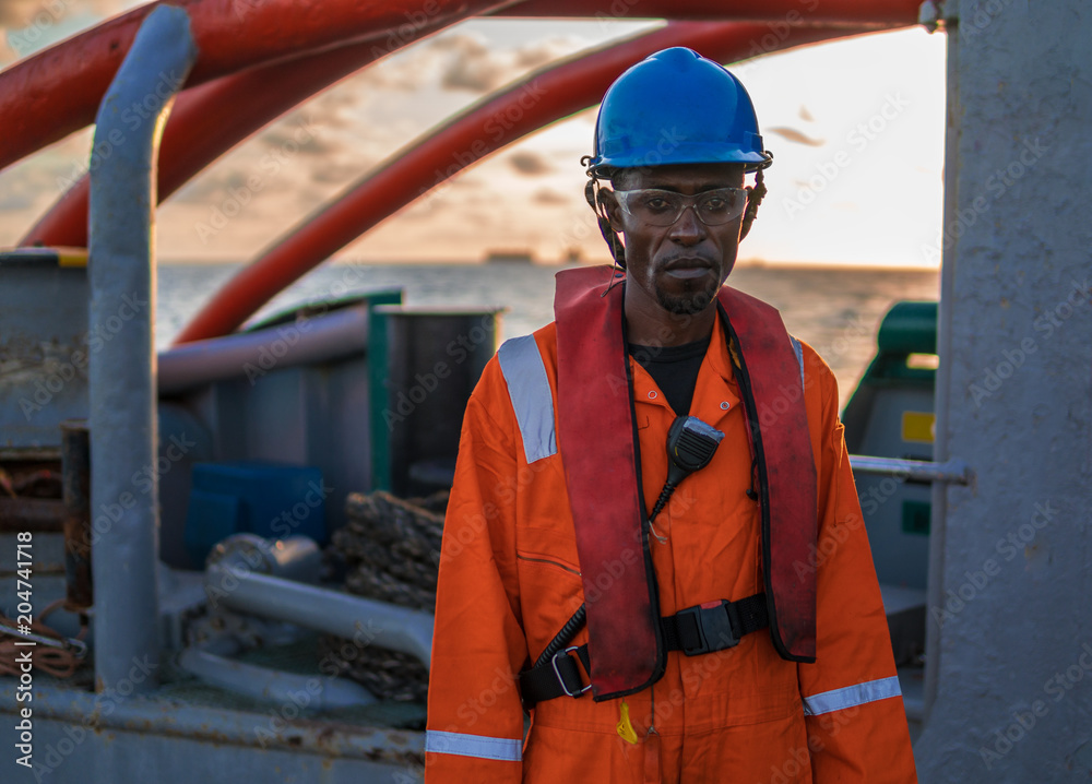rating Seaman AB or Bosun on deck of vessel or ship , wearing PPE ...