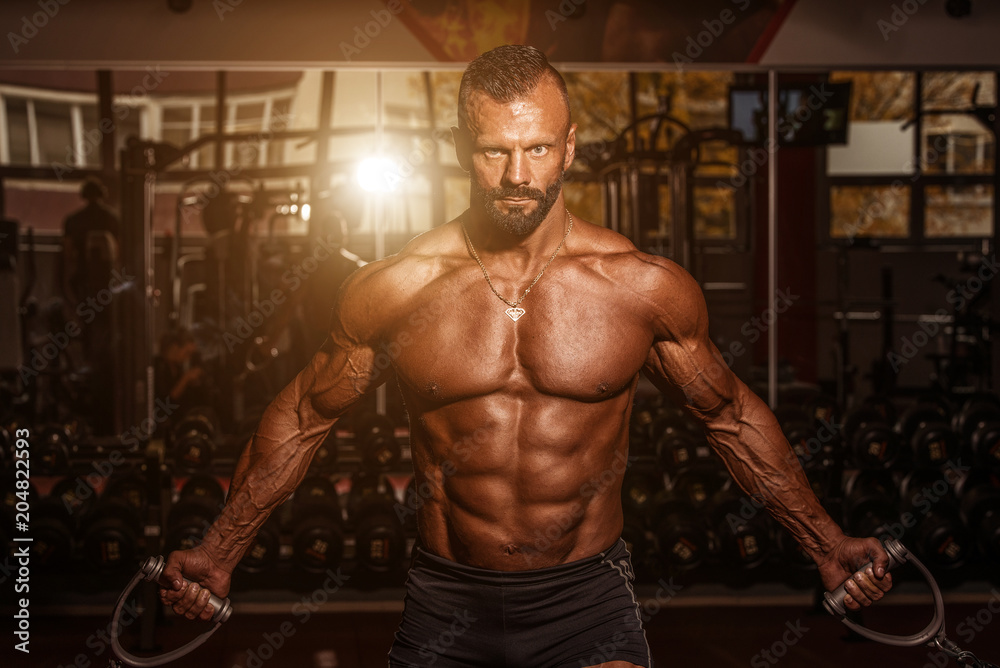 Handsome man with big muscles working out in gym. Muscular bodybuilder ...