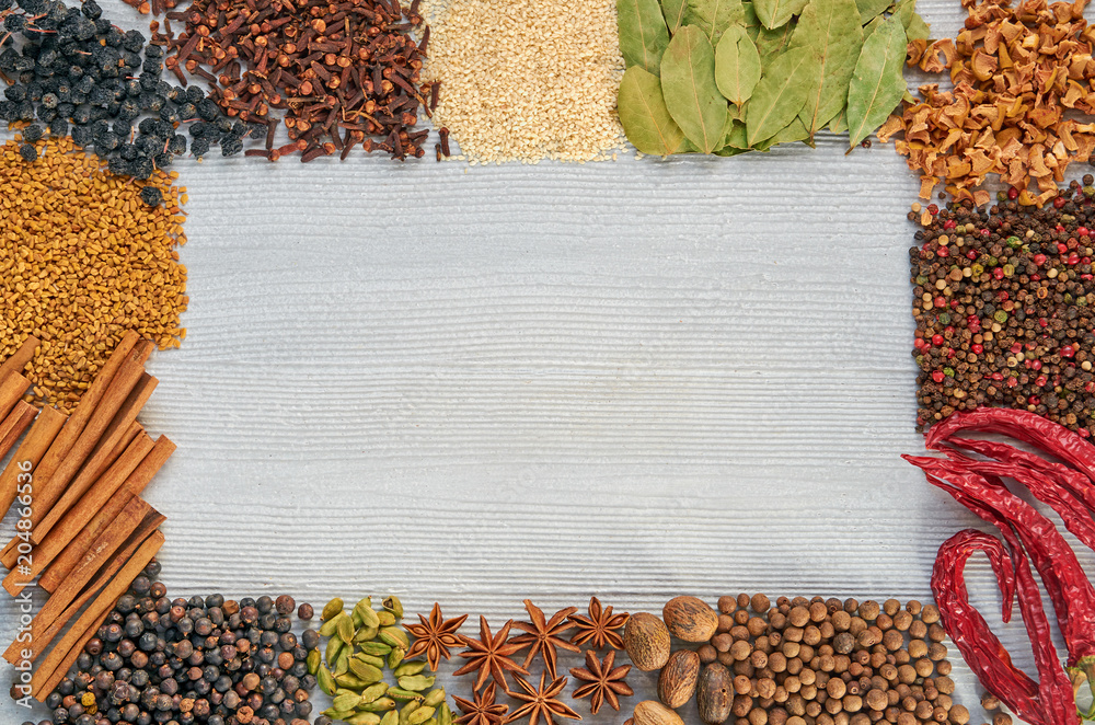 Various aromatic Indian spices and herbs on the gray kitchen table ...