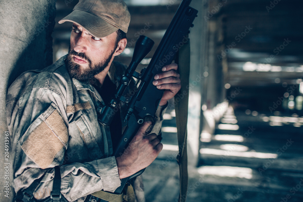 Careful and courageous man is sitting very close to column and holding ...