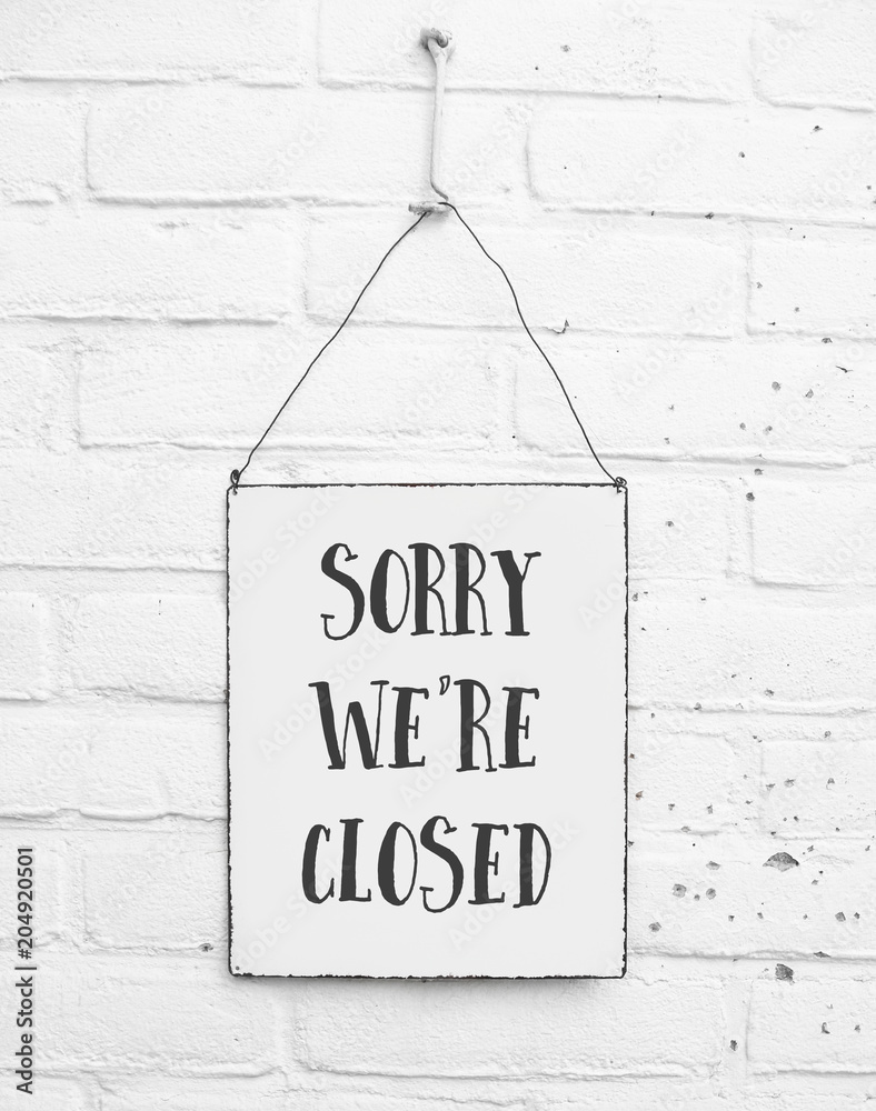 White square metal plate on white bricks background - with text sorry ...