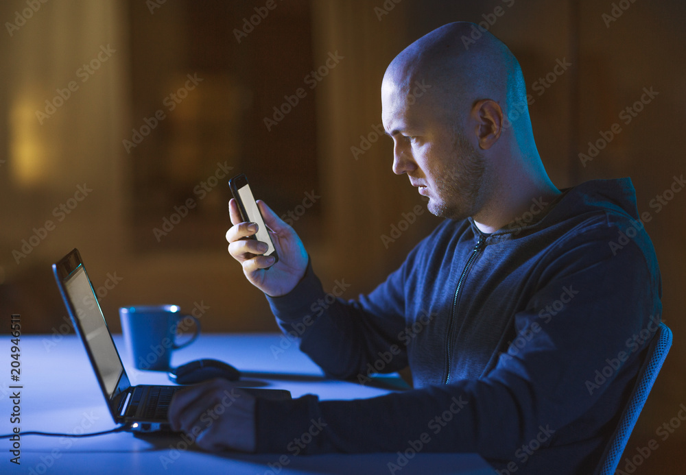 cybercrime, hacking and technology concept - male hacker with ...