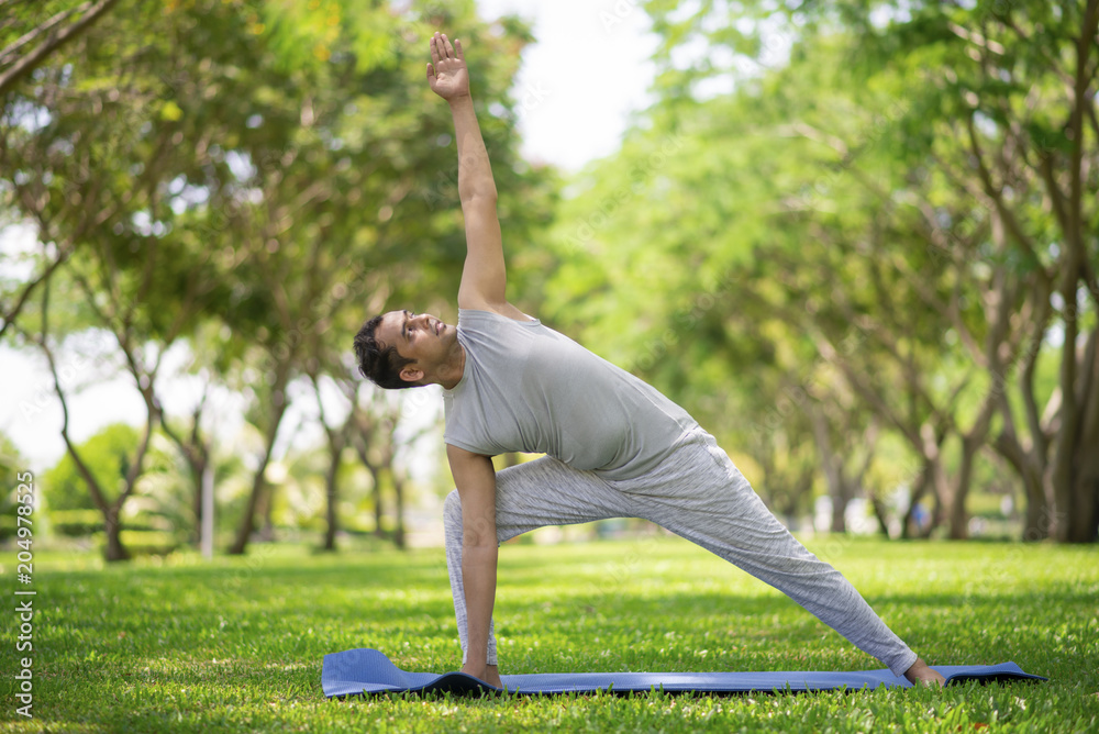 Inspired Indian man doing yoga asanas in city park. Young citizen ...