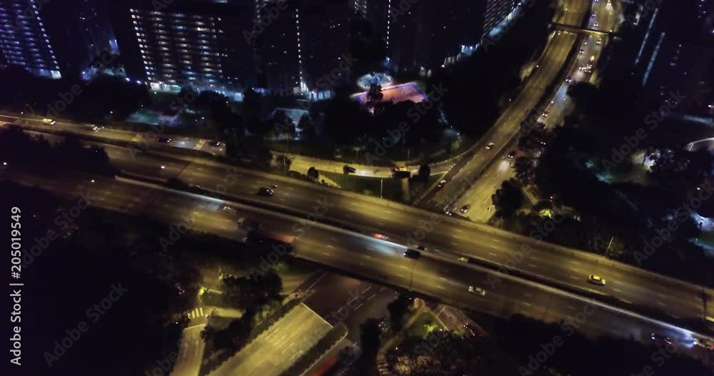 Vidéo Stock Cars driving on freeway interchange at night. Tilting drone ...