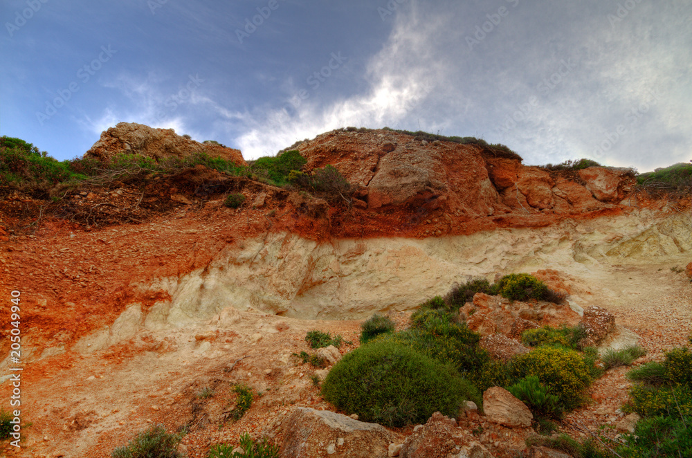Soil profile in a cliff, showing terra rossa, reddish soil, heavy and clay-rich, developed on a ...