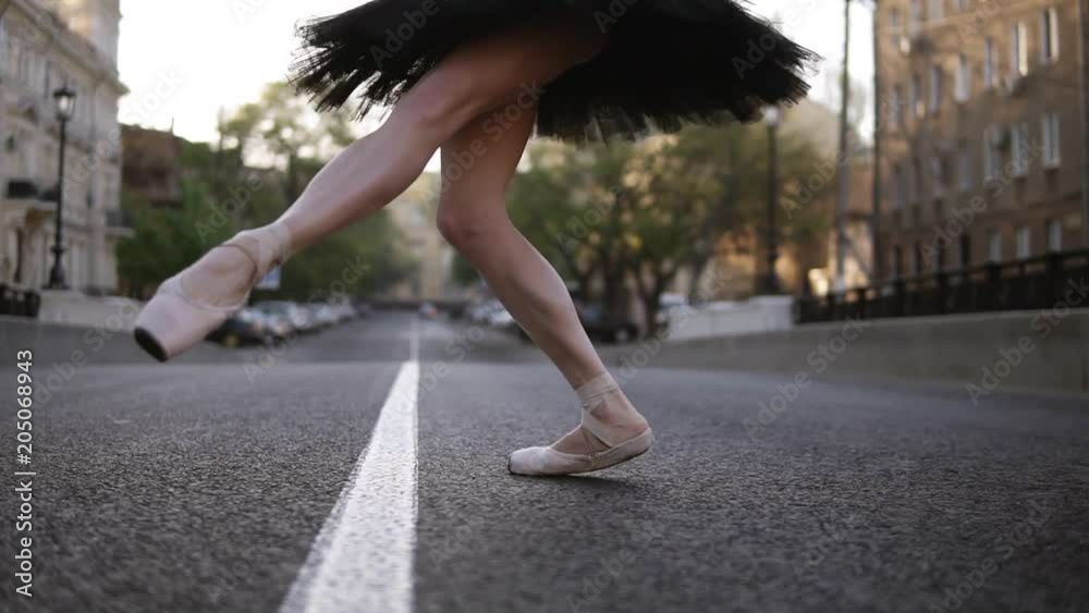 Elegant young ballet dancer on the street on an empty road. Stepping on ...