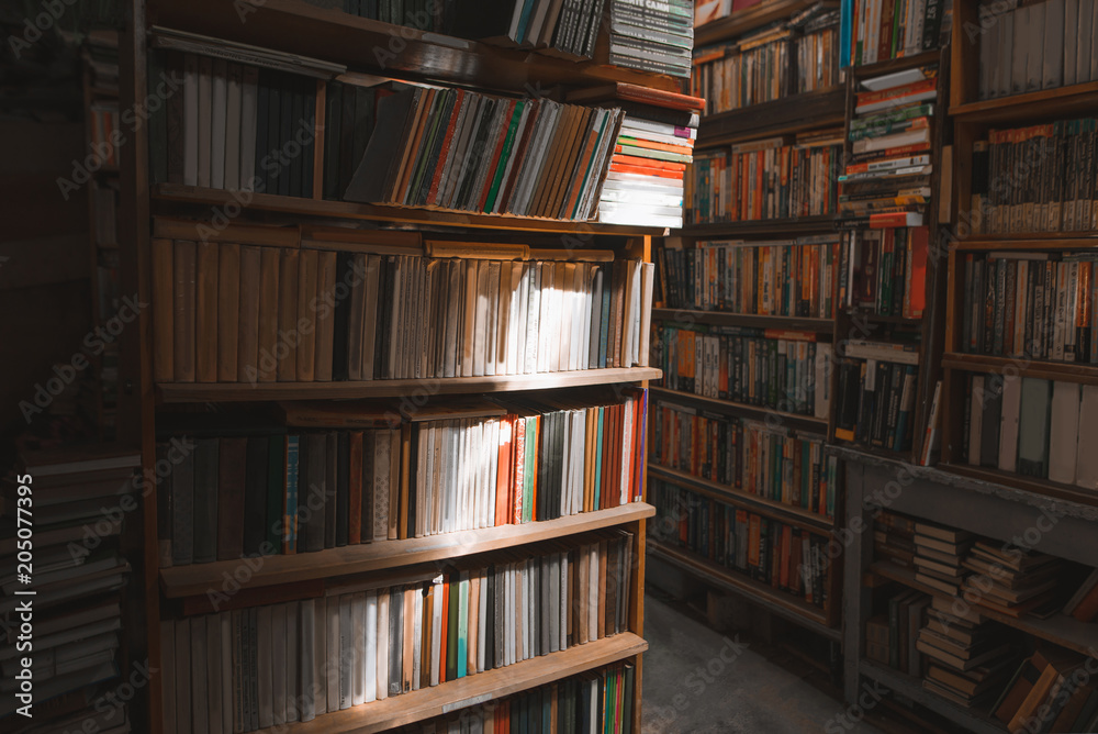 Old cozy library. Game of light and shadow on shelves with books in the ...