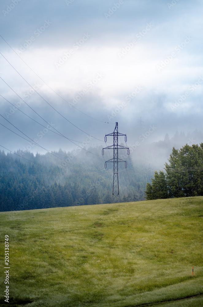 High voltage towers in a middle of forests and meadow. Electricity ...