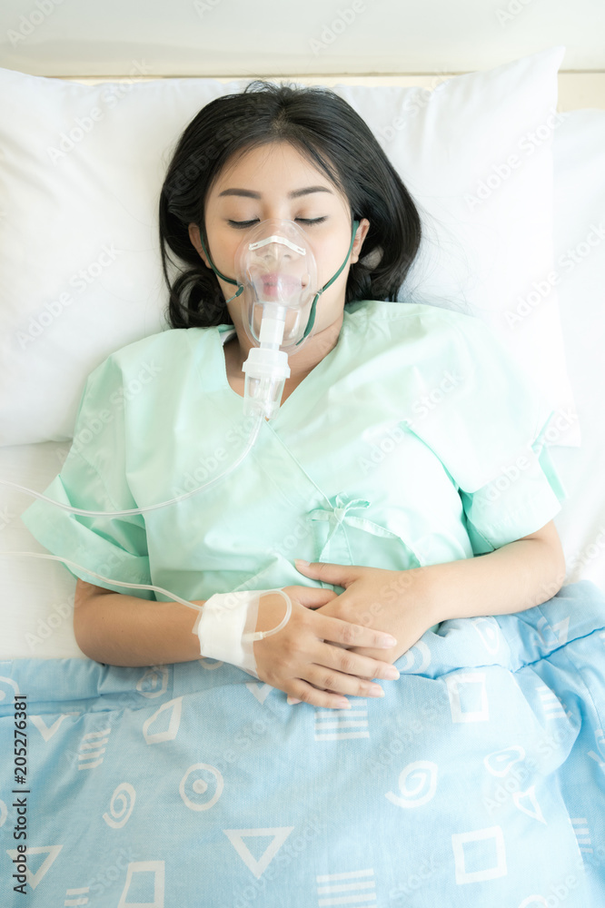Young patient alone in bed. Sleeping in hospital bed. Oxygen mask on ...