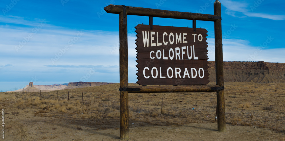 Welcome to Colorado sign wiht blue sky and mountains in the background ...