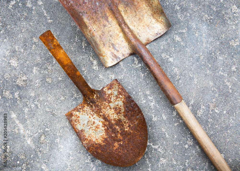 old and rusted shovel blades isolated close-up against weathered ...
