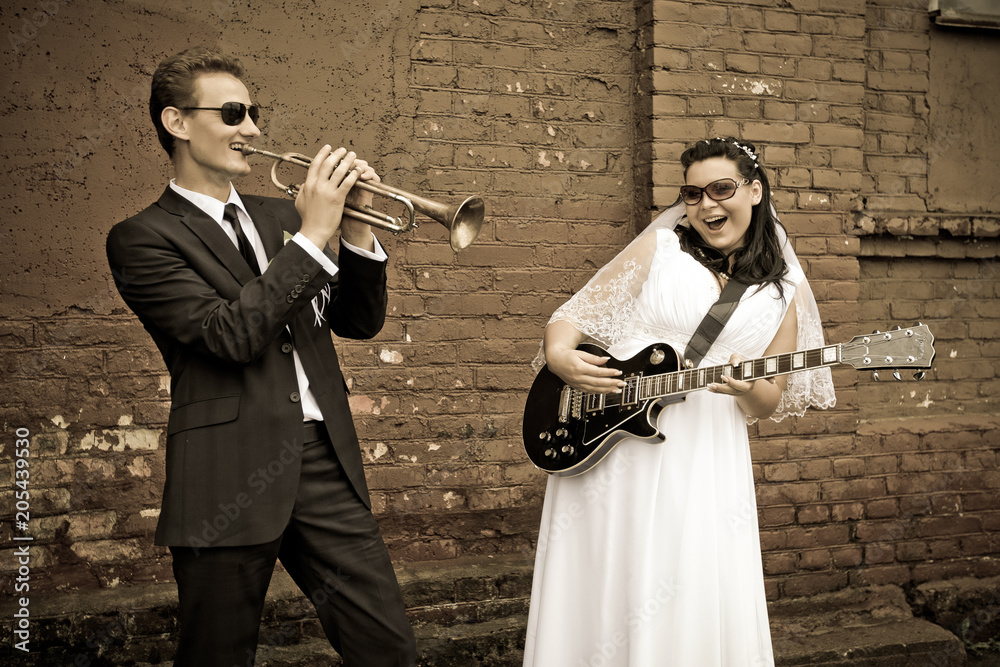 The groom plays the saxophone and the bride on the electric guitar on ...