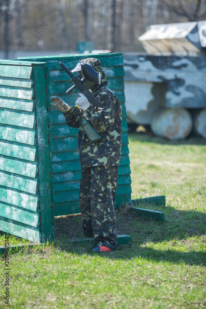 two teams of paintball players in camouflage uniform and protective ...
