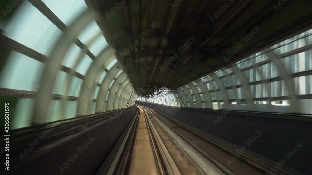 Train moves along metro or subway railroad half-open tunnel and passes ...