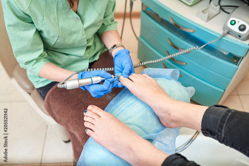 Pedicure for a woman in the nail salon. Master using professional ...