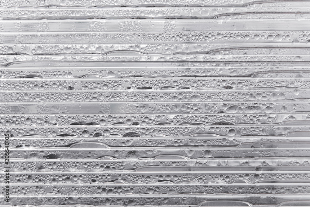 Water drop on reflective clear plastic wrap. The texture of the drops ...