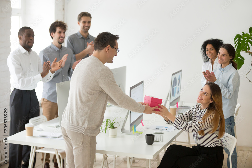 Friendly diverse corporate team congratulating happy female colleague ...