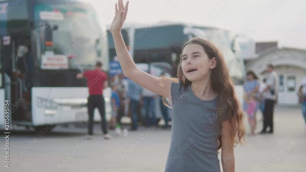 little girl waving her hand at the bus station slow motion video ...