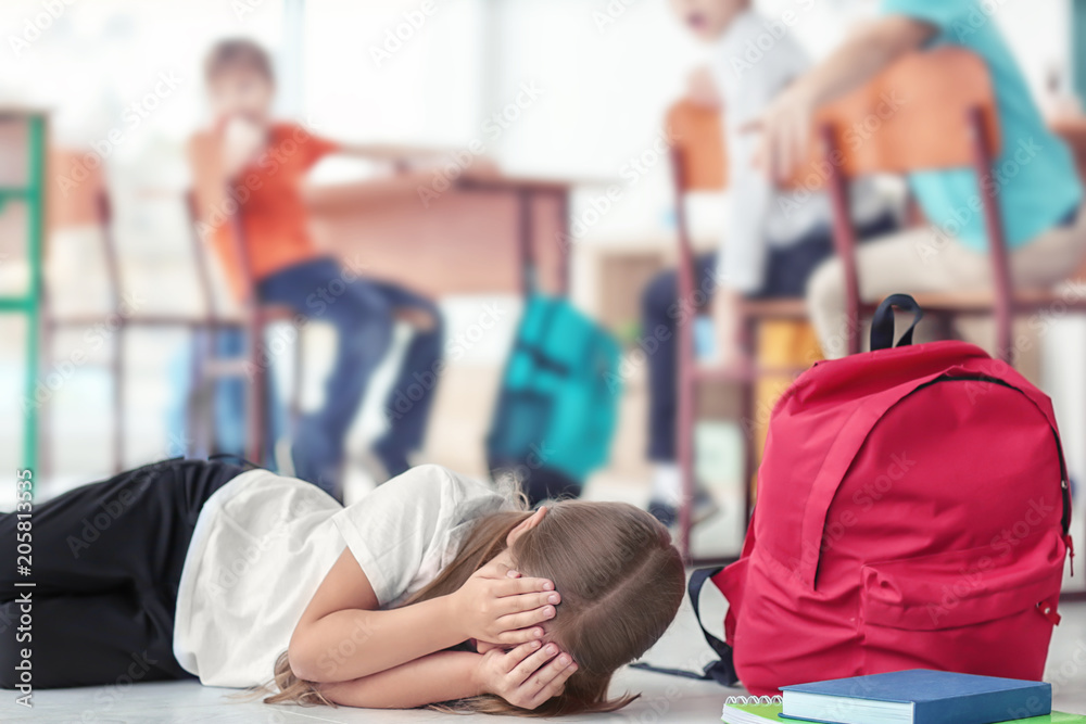 Little girl crying on floor in classroom. Bullying in school Stock ...