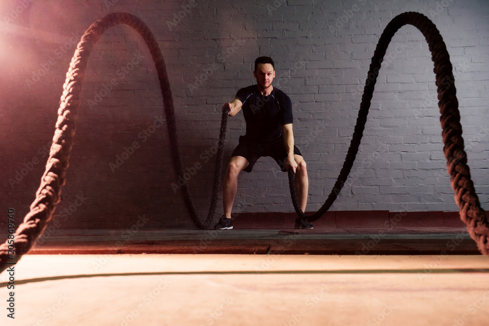 young and handsome male athlete man doing exercises for the muscles of ...