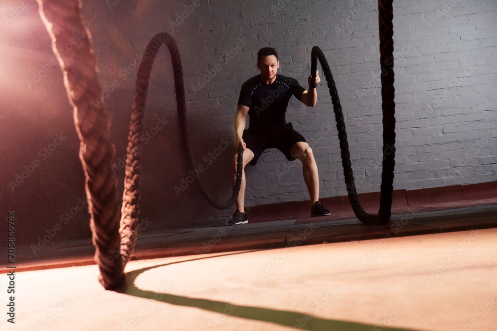 young and handsome male athlete man doing exercises for the muscles of ...