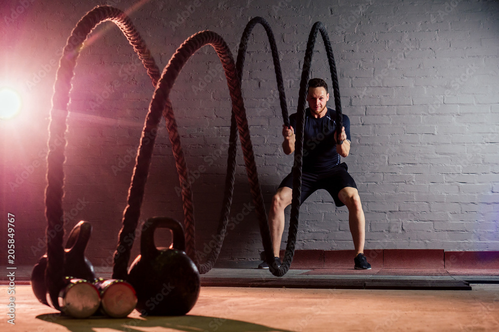 young and handsome male athlete man doing exercises for the muscles of ...