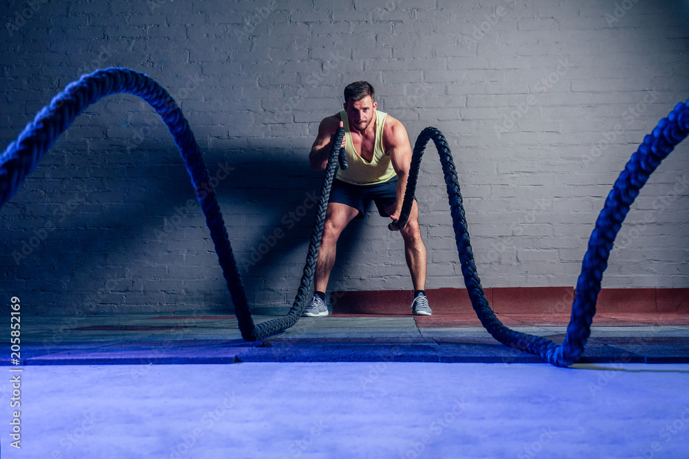 young and handsome male athlete man doing exercises for the muscles of ...