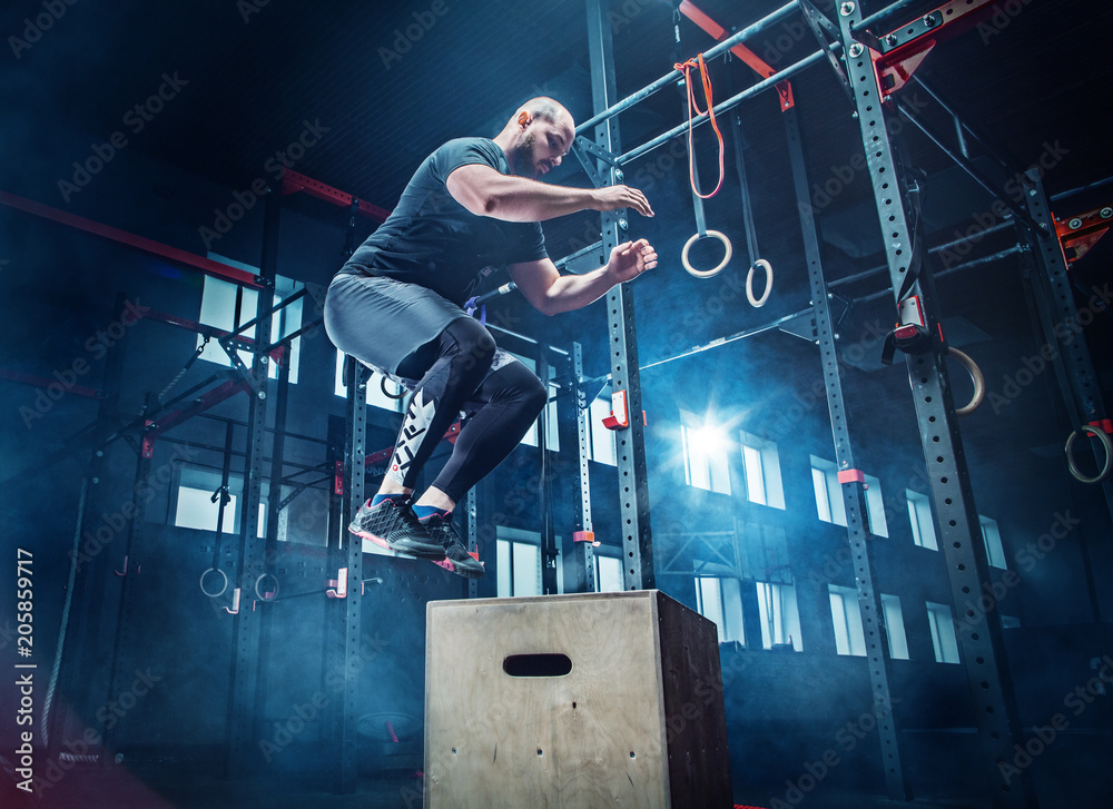 Man jumping during exercises in the fitness gym. CrossFit. Stock Photo ...