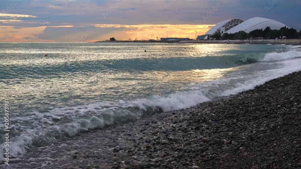 surf of the sea wave on the background of the Golden sunset. pebble ...