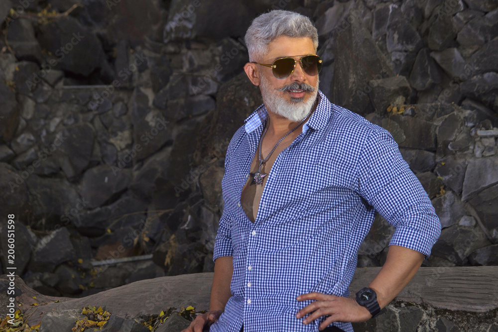 Side pose of smiling nan with grey hair and beard in smart casuals ...