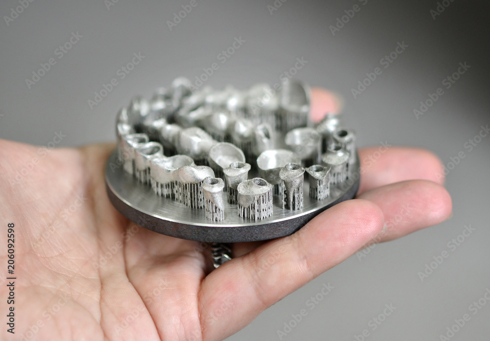 Man Is Holding Object Printed On Metal 3d Printer Dental Crowns man-is-holding-object-printed-on-metal-3d-printer-dental-crowns