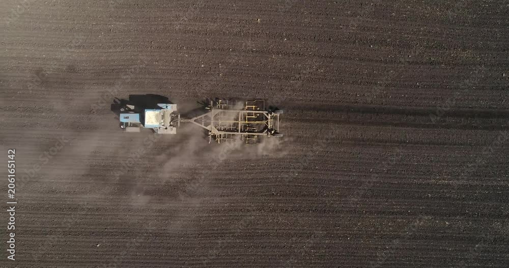 Aerial view of agricultural tractor cultivating field. Tractor At Work ...