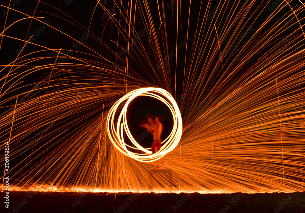 Fireman Show on the beach dance man juggling with swing fire sparks in ...