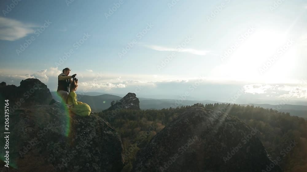 Extreme haircut on top of the cliff. Young male hairdresser doing a ...