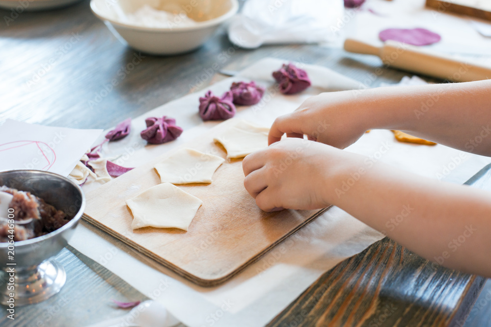 cooking class, culinary. food and people concept/ molding of pelmeni or ...