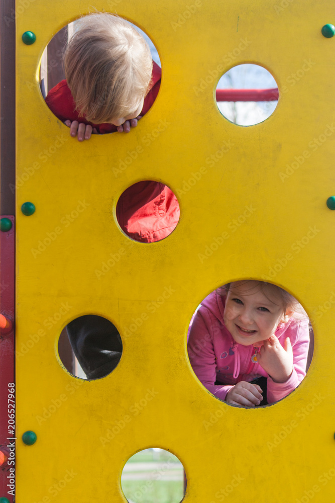 Children, boy and girl play hide-and-seek in the playground. The kids ...