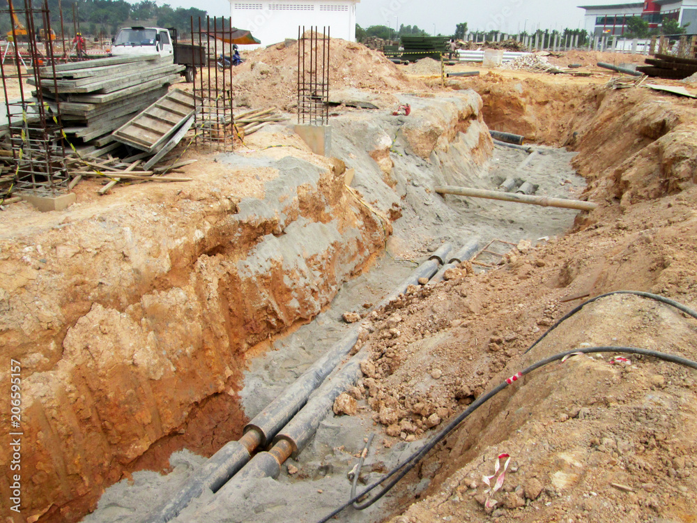 Underground utility and services pipe laid by workers in the trenches ...
