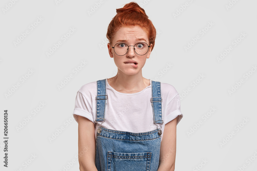 Portrait of confused female student curves lips and looks nervously at ... Portrait of confused female student curves lips and looks nervously at ...