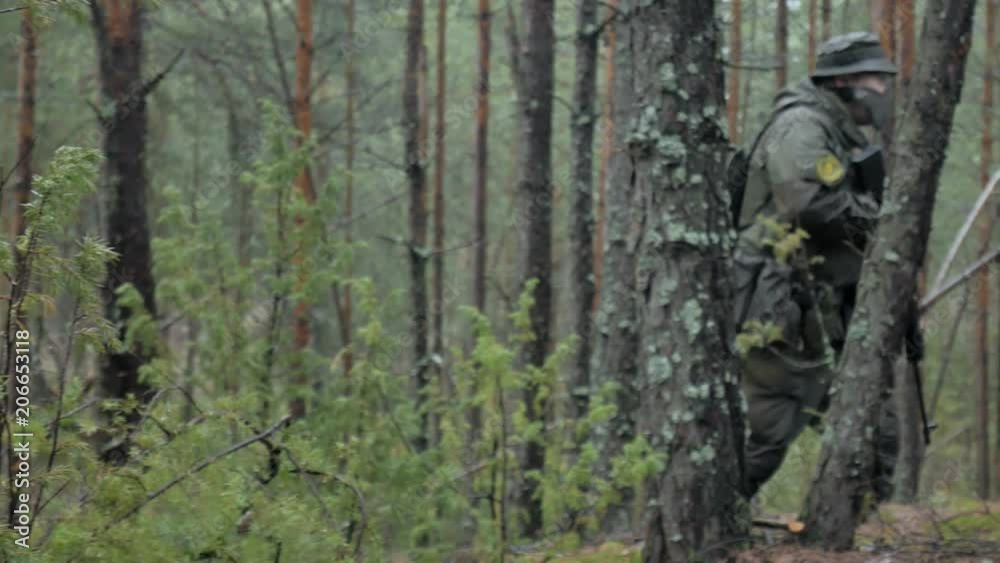 Soldiers in camouflage with combat weapons make their way outside the ...