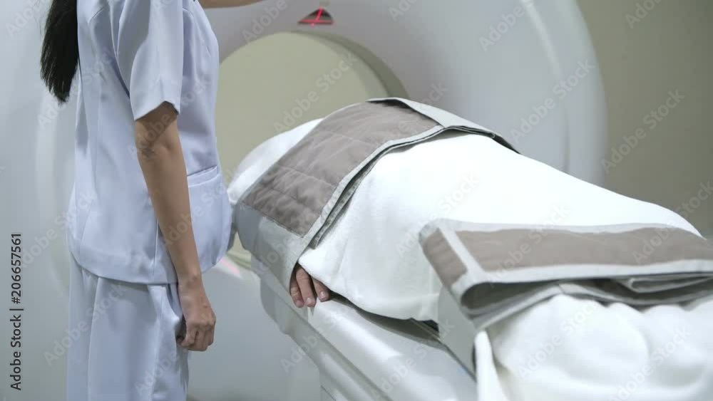Patient in MRI machine for a CT scan. Senior man cover in blanket going ...