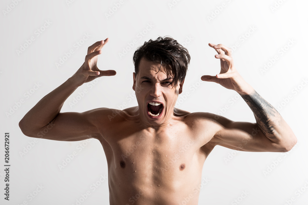 Feeling furious. Portrait of shirtless young man is expressing anger ...