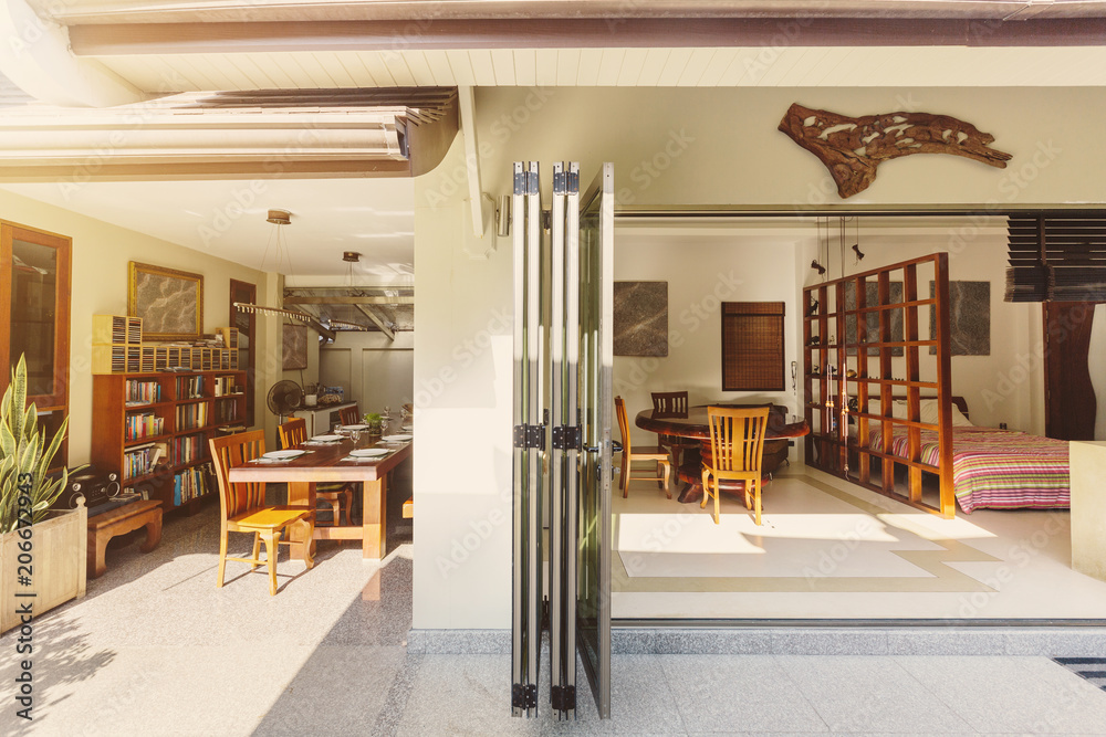 Big open dining room with bookshelf and bedroom with folding doors in ...
