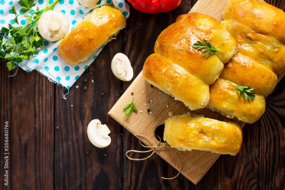 Pies with mushrooms and rice on the kitchen wooden table. Traditional ...
