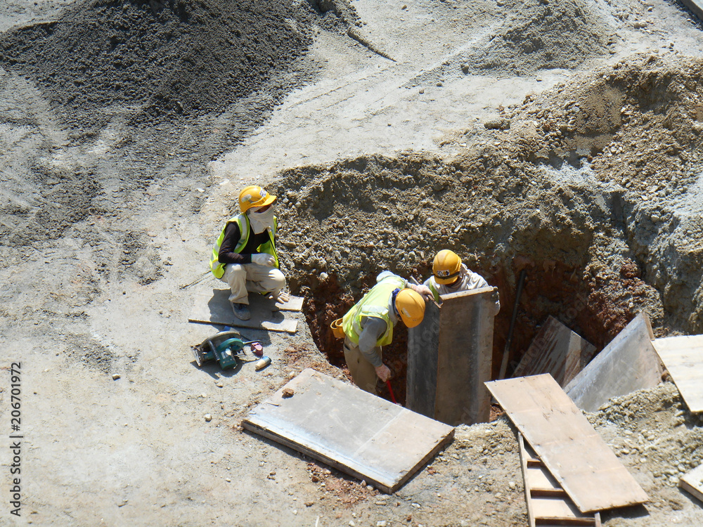 Underground drainage manhole under construction by construction workers ...