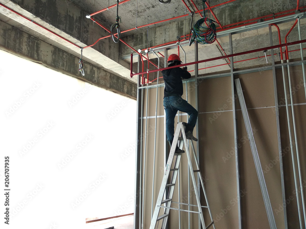 Drywall installation work in progress by construction workers at the ...