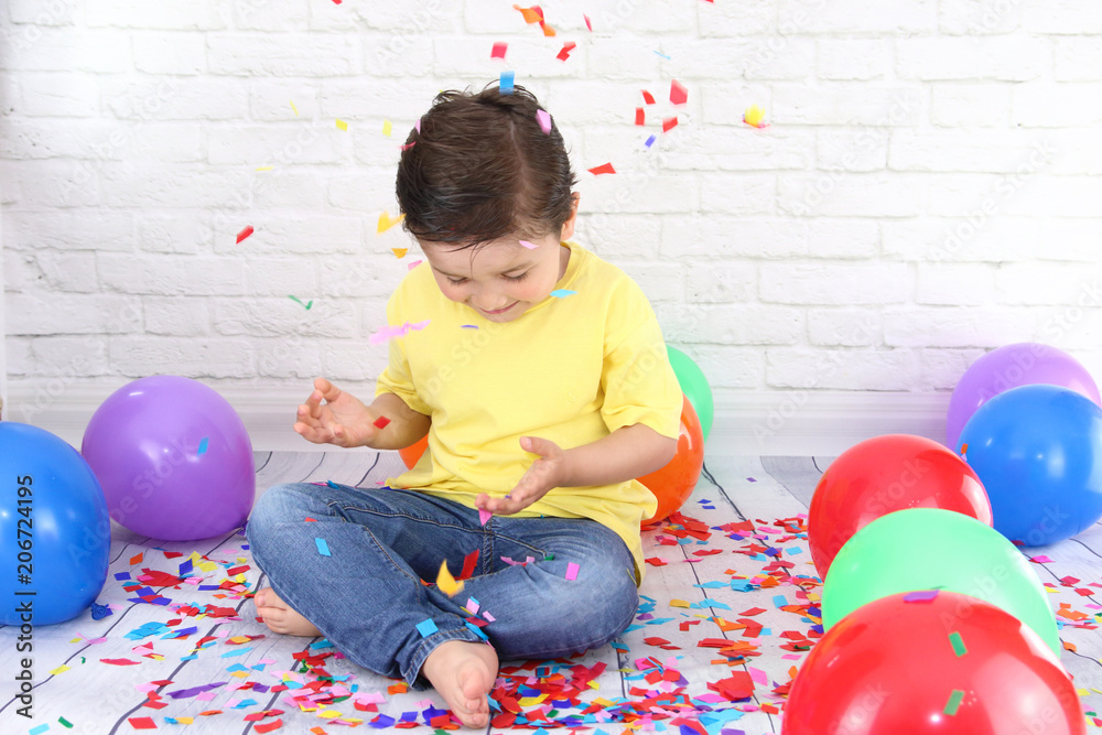 niño feliz lanzando confetti de colores rodeado de globos Stock Photo ...