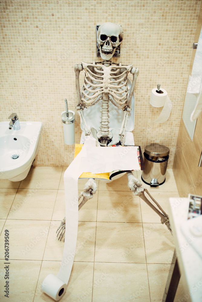 Human skeleton with book in hand sitting on toilet Stock Photo | Adobe ...