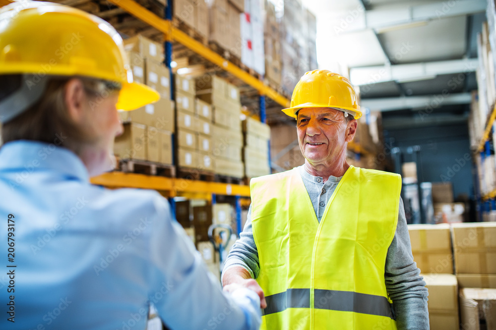 Senior woman manager and man worker working in a warehouse. Stock Photo ...