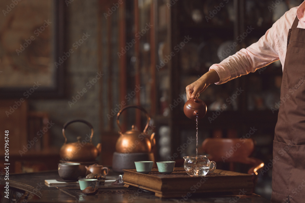 Young professional pouring tea from a teapot Stock Photo | Adobe Stock