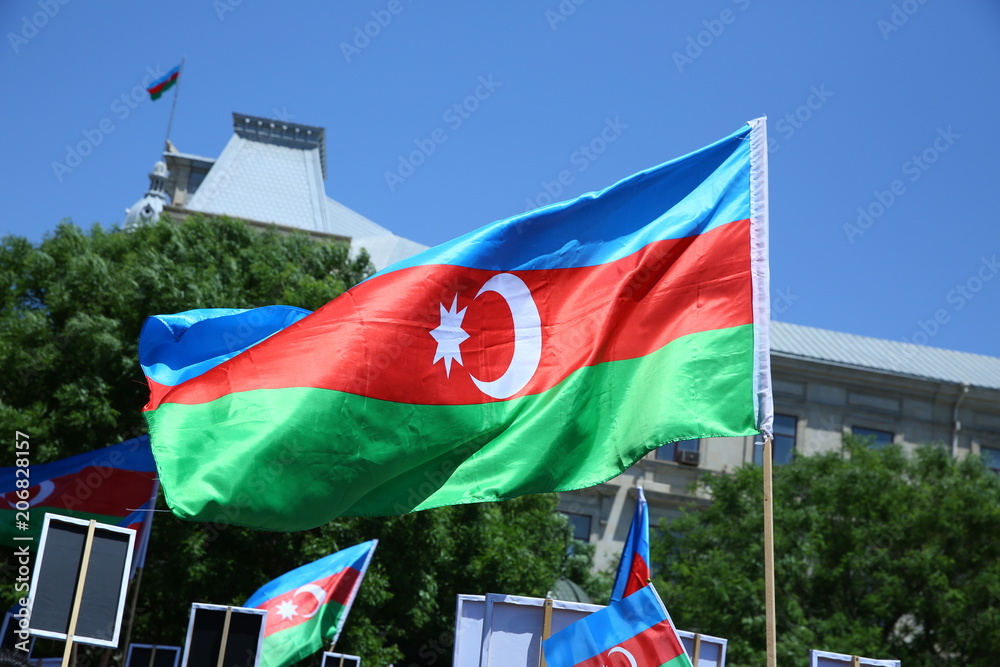 The Azerbaijani flag is on the background of the city . Action ...